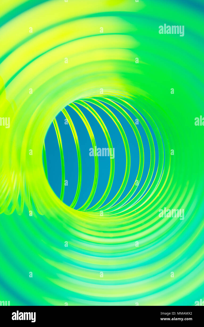 Spiral spring toy over blue background Stock Photo - Alamy