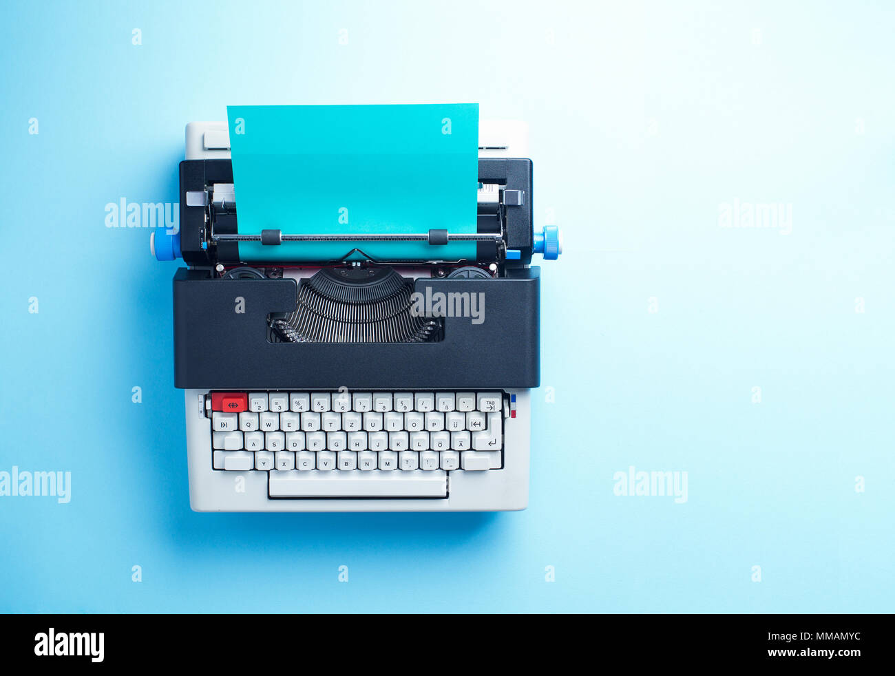 Typewriter with blue paper over blue background, top view Stock Photo ...