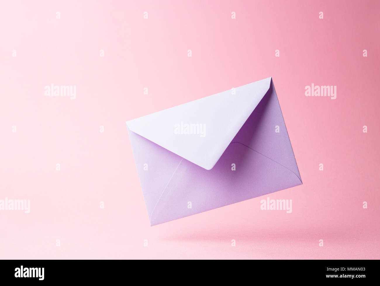 Purple envelope dropped over pink background Stock Photo - Alamy