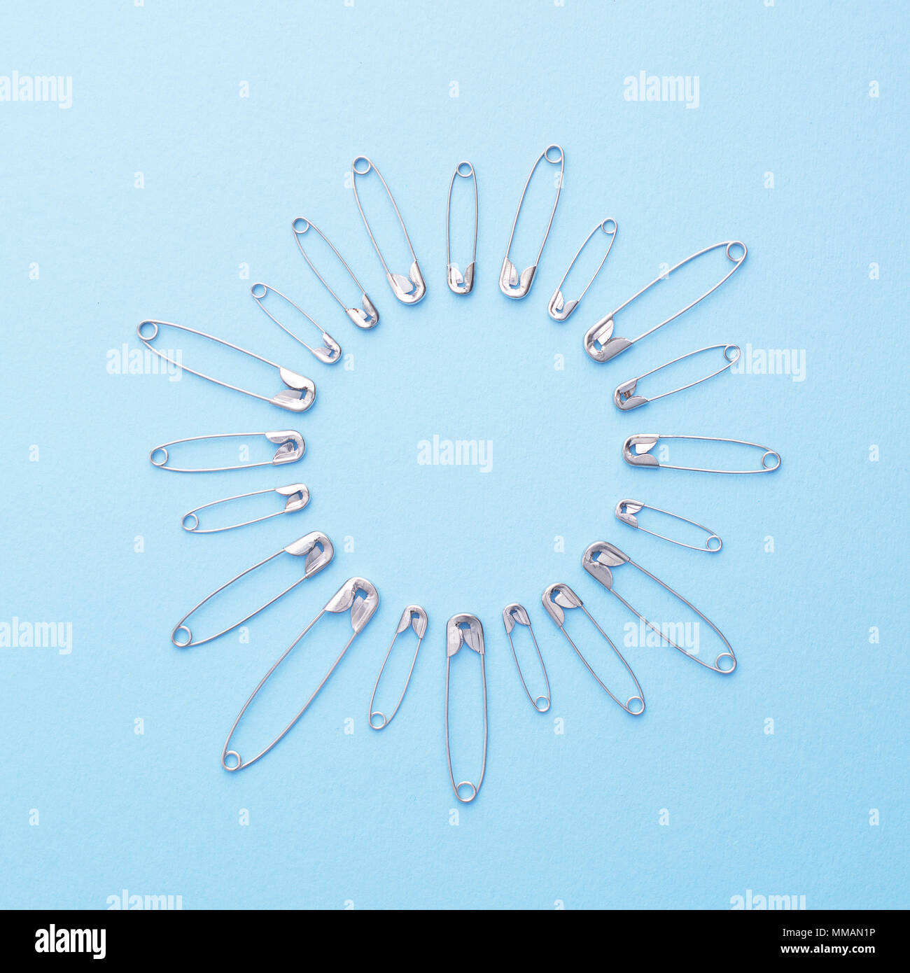 Safety pins organized in a circle over blue background Stock Photo - Alamy