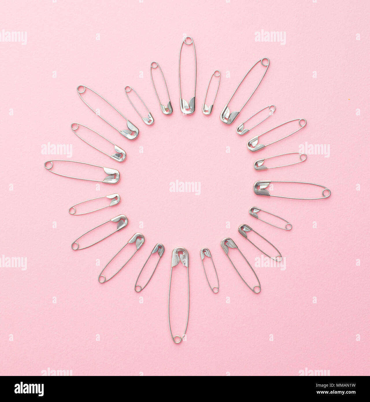 Safety pins organized in a circle over pink background Stock Photo - Alamy