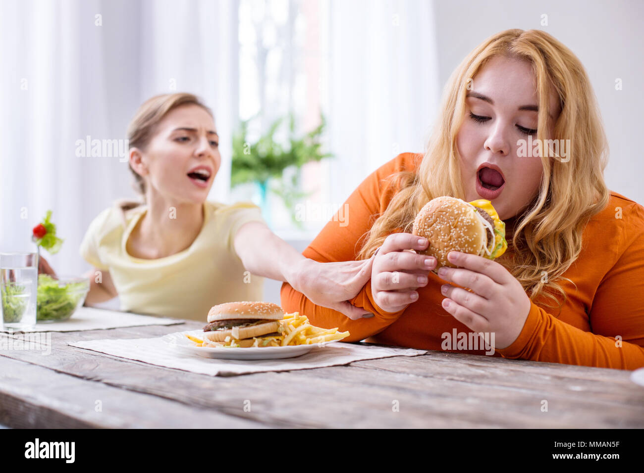Satisfied fat woman eating a sandwich Stock Photo - Alamy