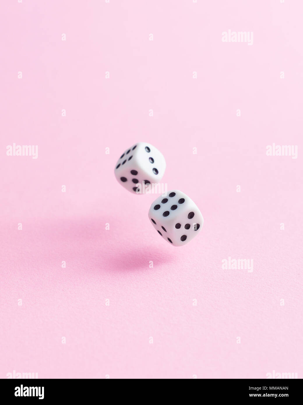 Two dice fall over pink background Stock Photo - Alamy