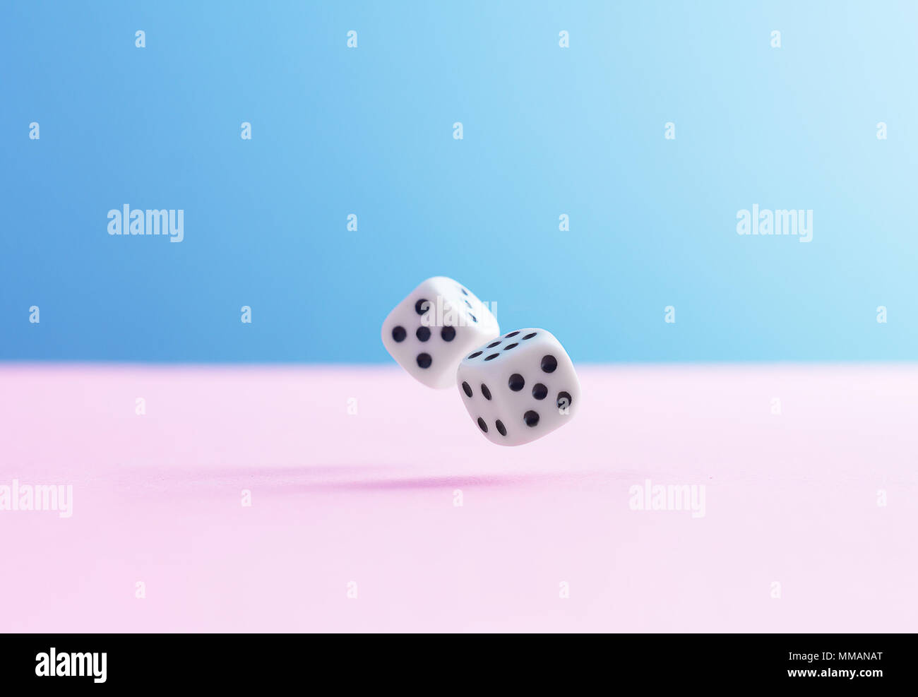 Two dice fall over pink background Stock Photo - Alamy