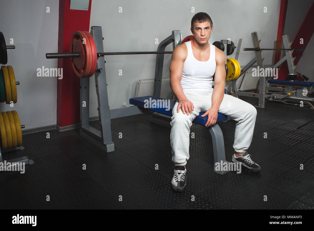 white muscular man in gym interior sitting on bench with barbell Stock ...