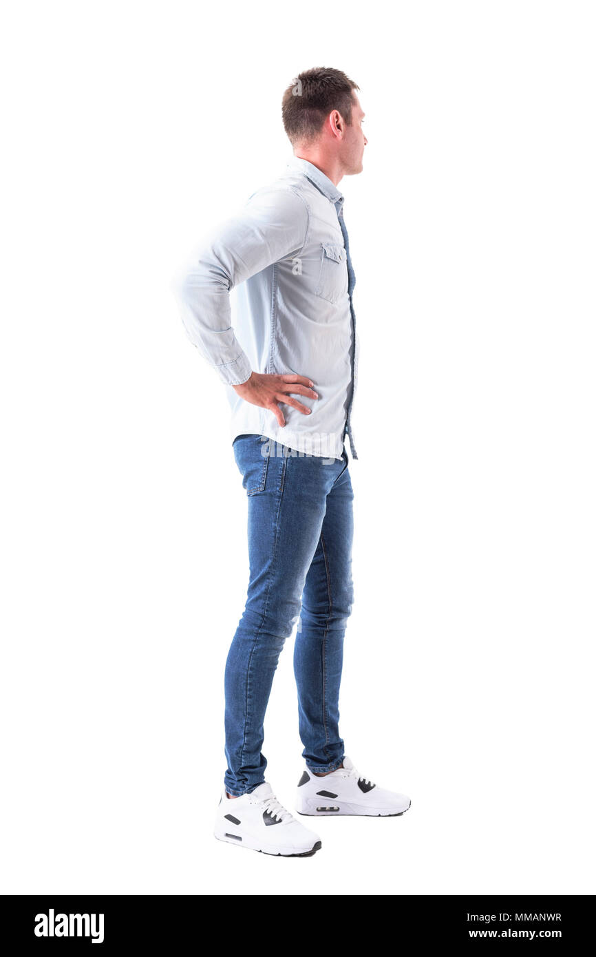 Young stylish business man with hands on hips looking away. Side view ...