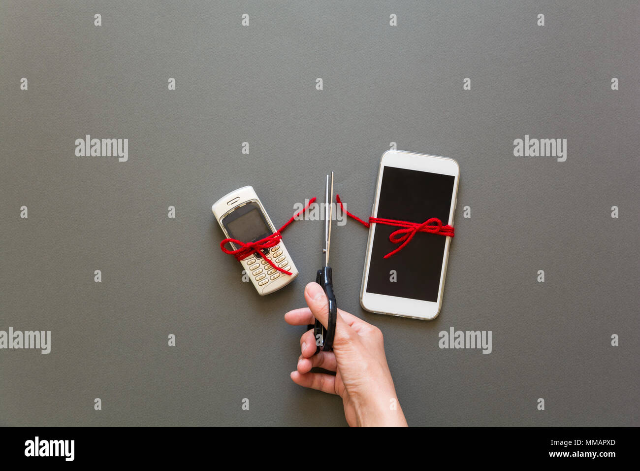 Old phone and new smartphone connected by red pulse laying on grey ...