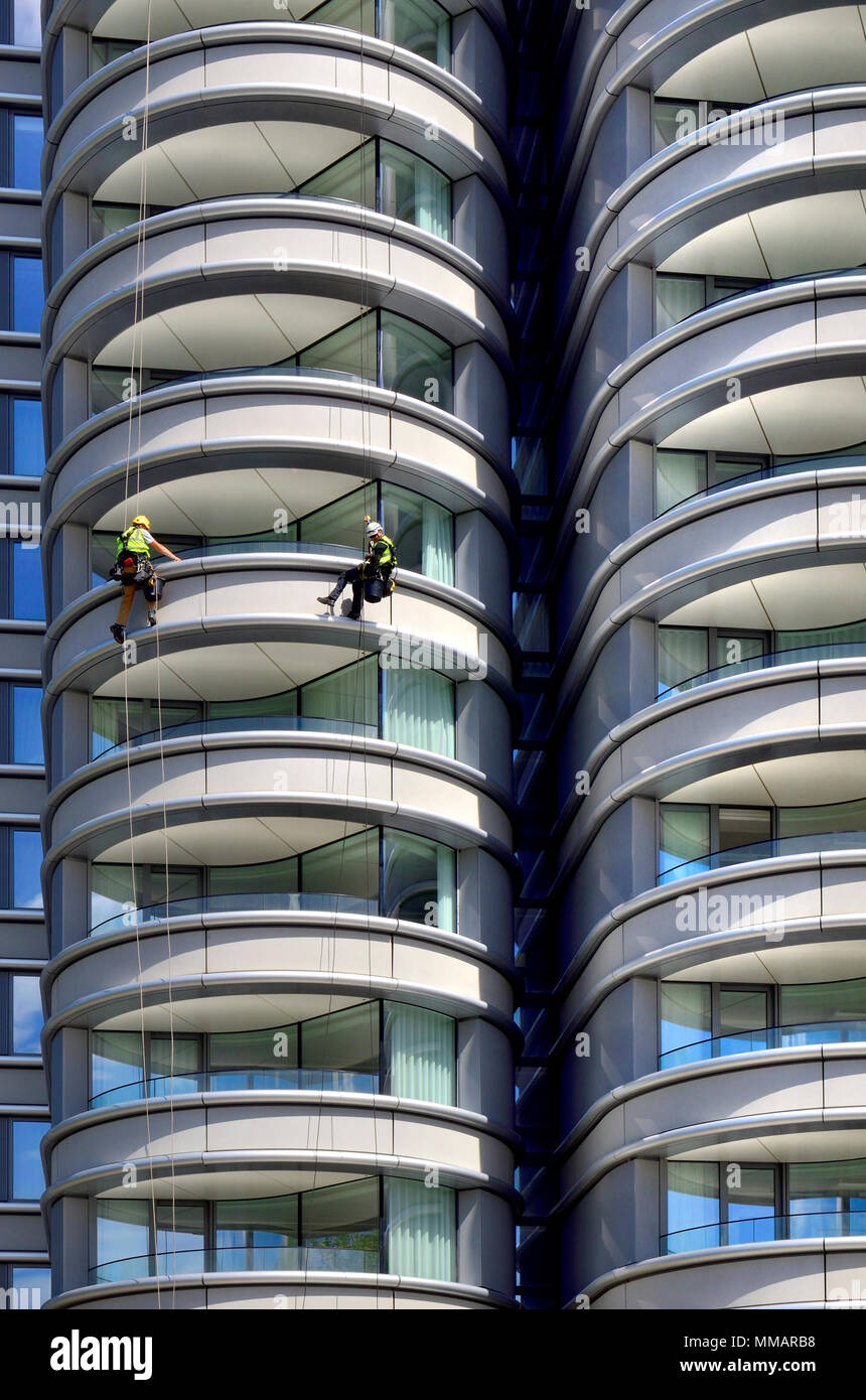 London,England, UK. Maintenance workers abseiling down the building ...
