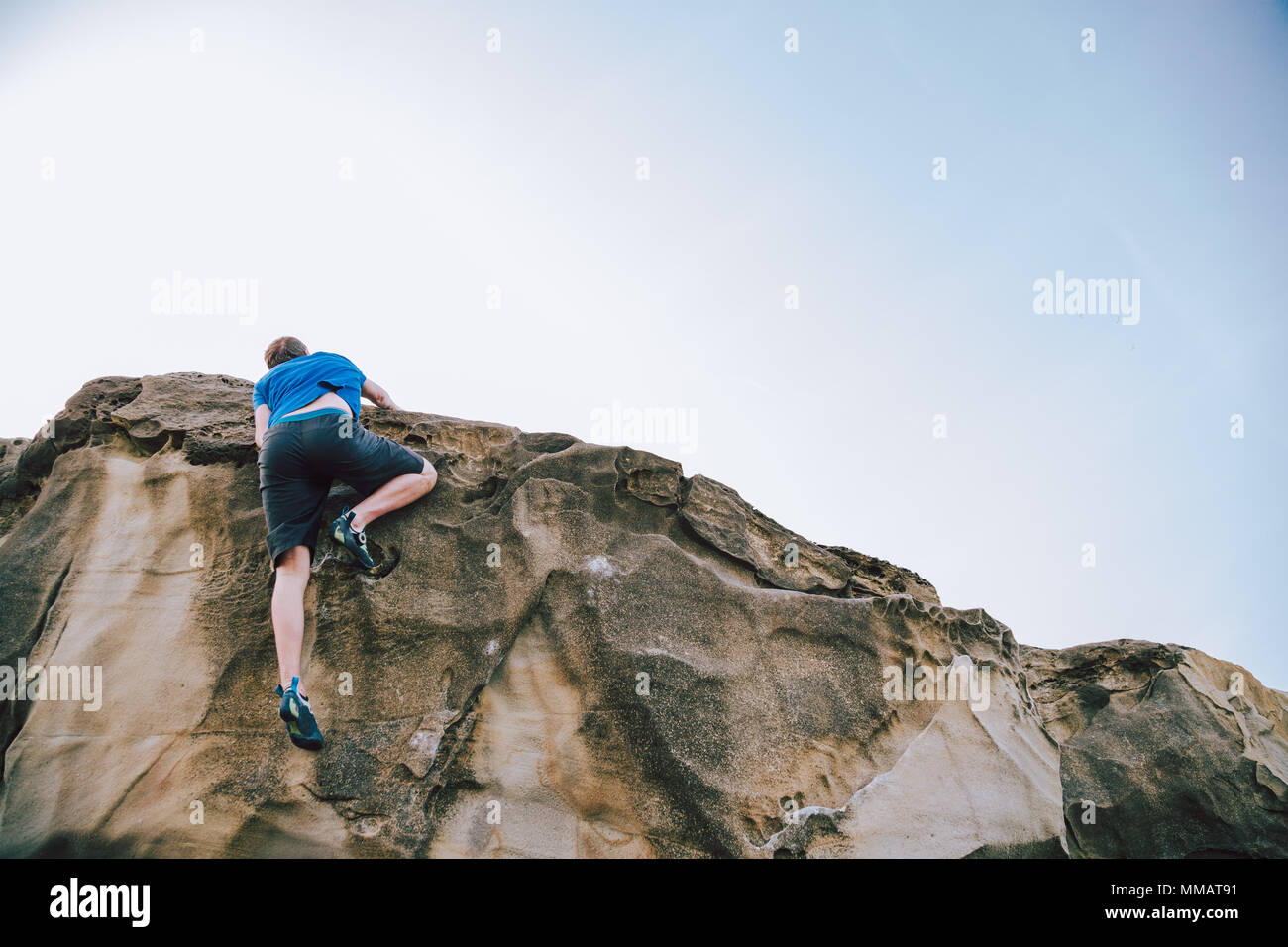 Young rock climber man reaching the top of the wall Stock Photo - Alamy