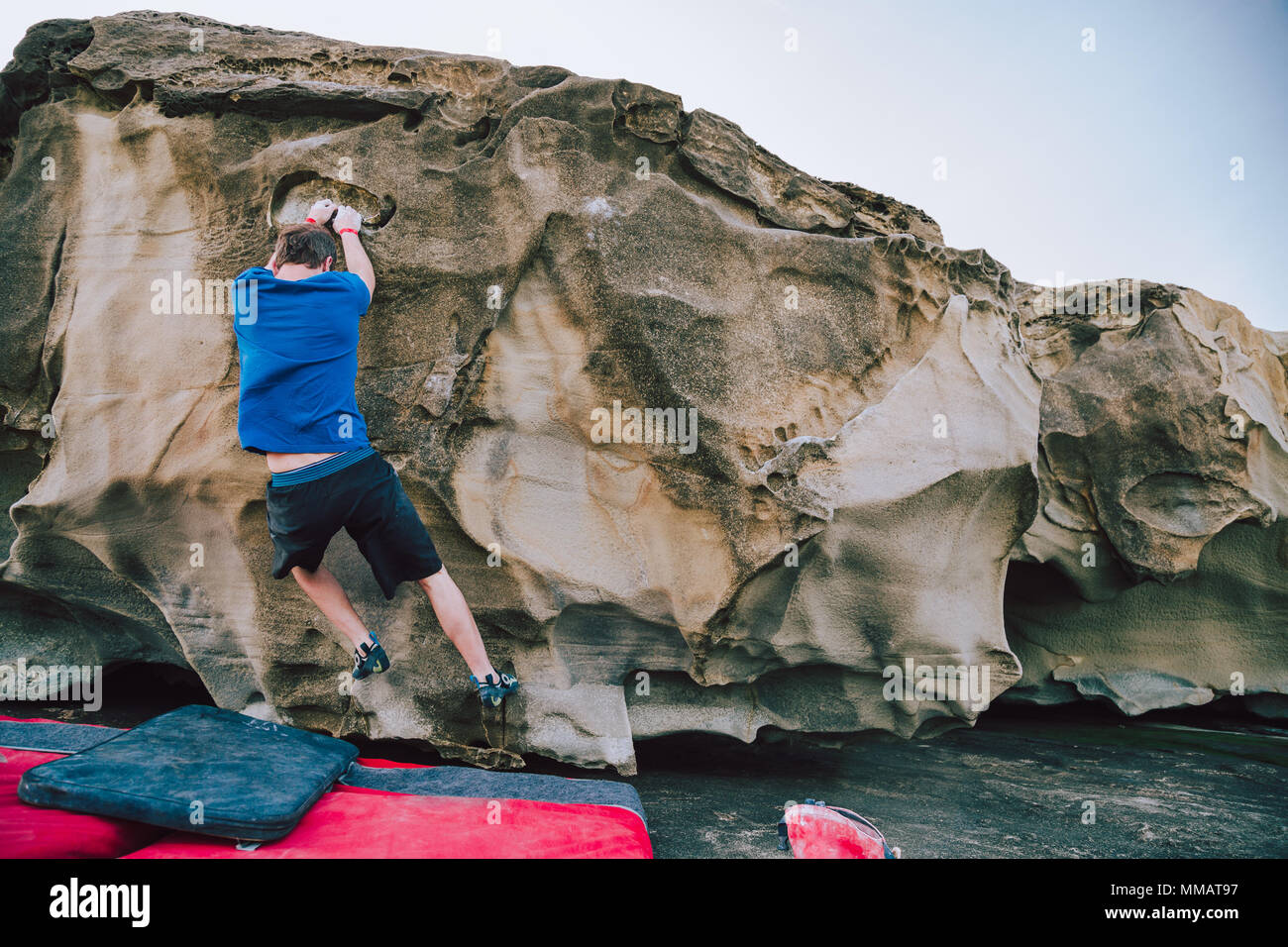 Rock climbing man starting the climb of a wall Stock Photo - Alamy