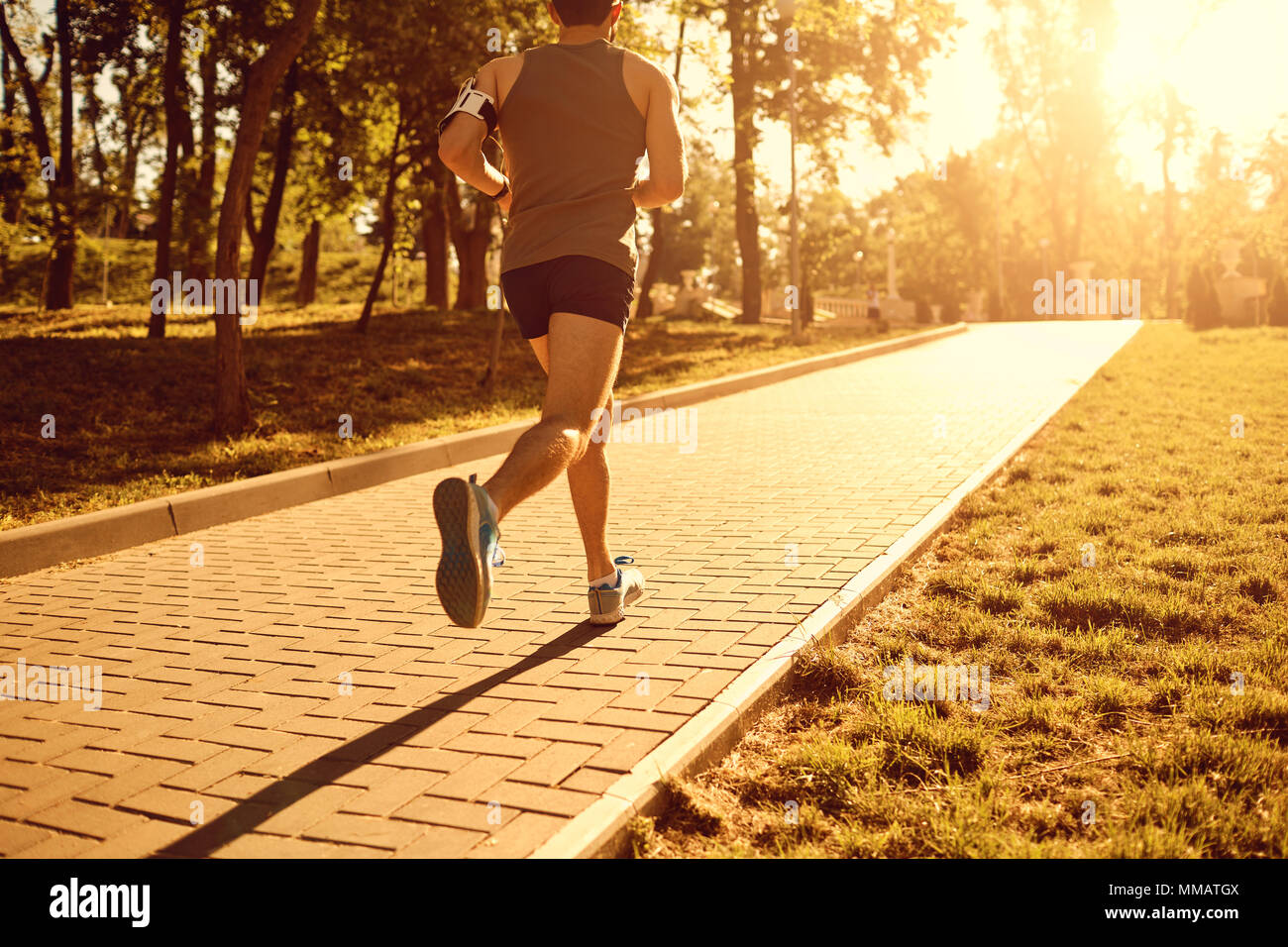 Young men running in park hi-res stock photography and images - Alamy