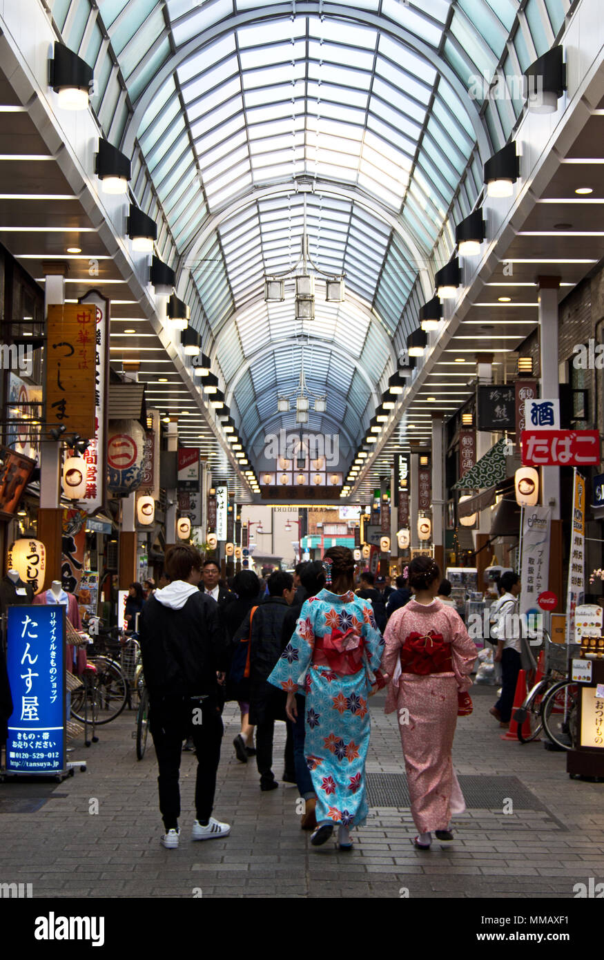 Girls in traditional kimonos and other shoppers inside a covered ...