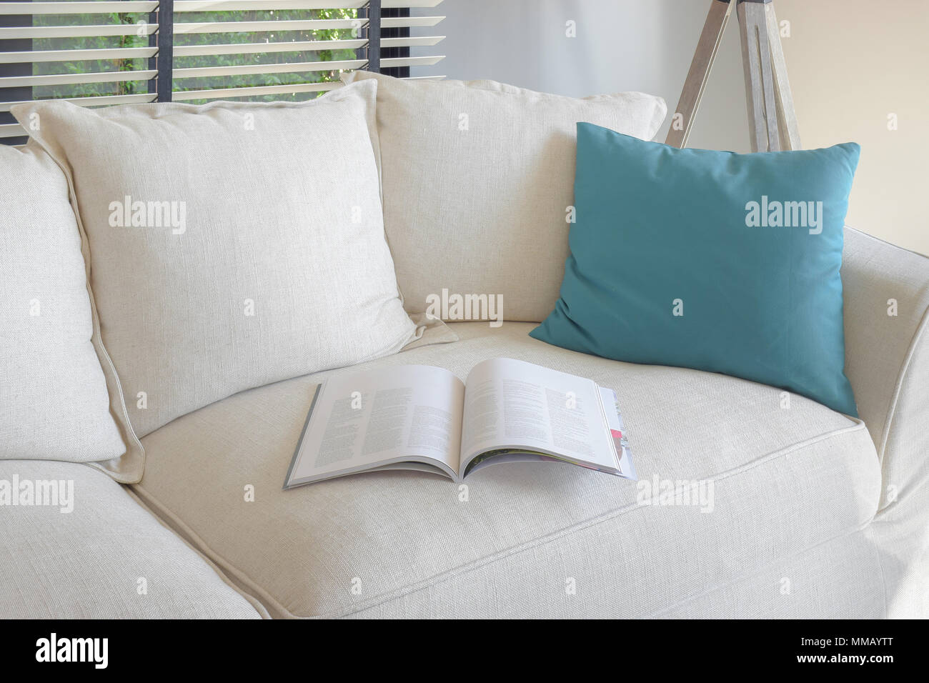 Book on white sofa and green pillow in living room Stock Photo - Alamy