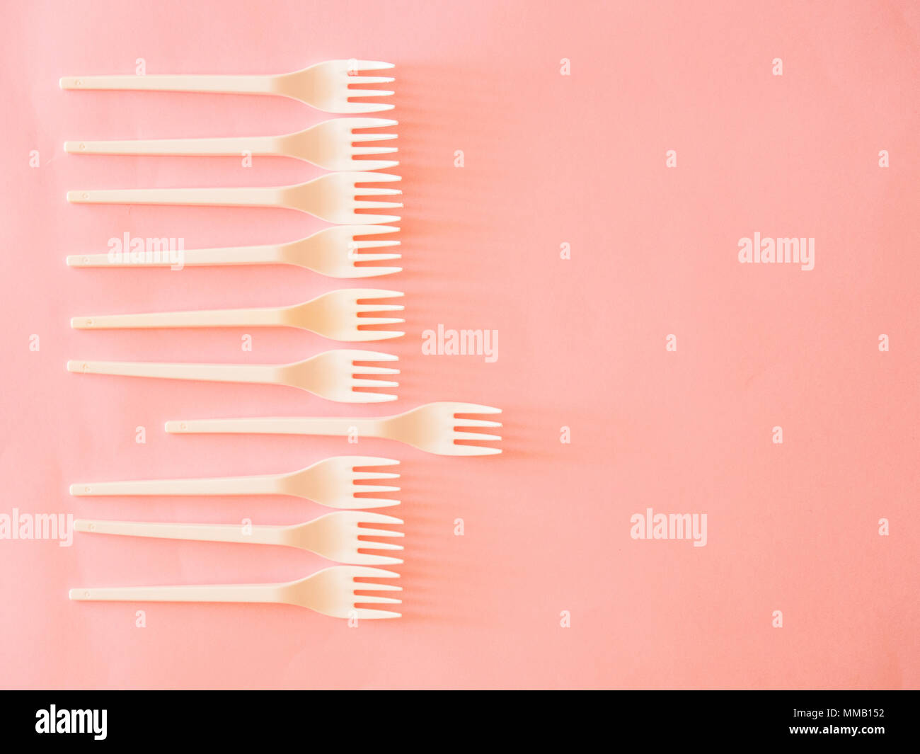 Plastic fork pattern on pink background Stock Photo - Alamy