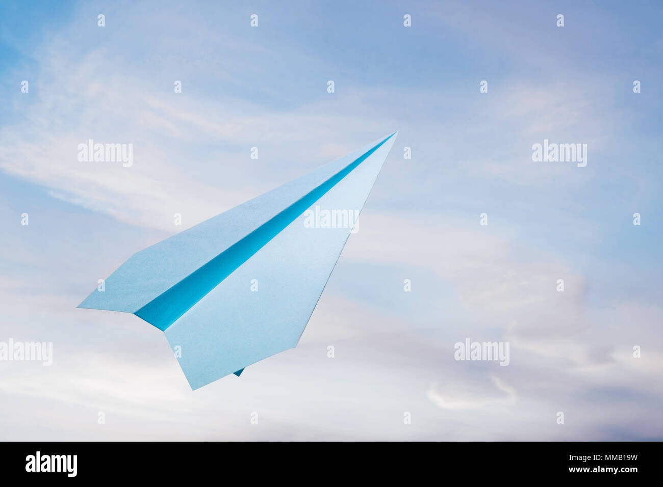 Blue paper plane agains cloudy sky. Travel, flight, freedom and ...