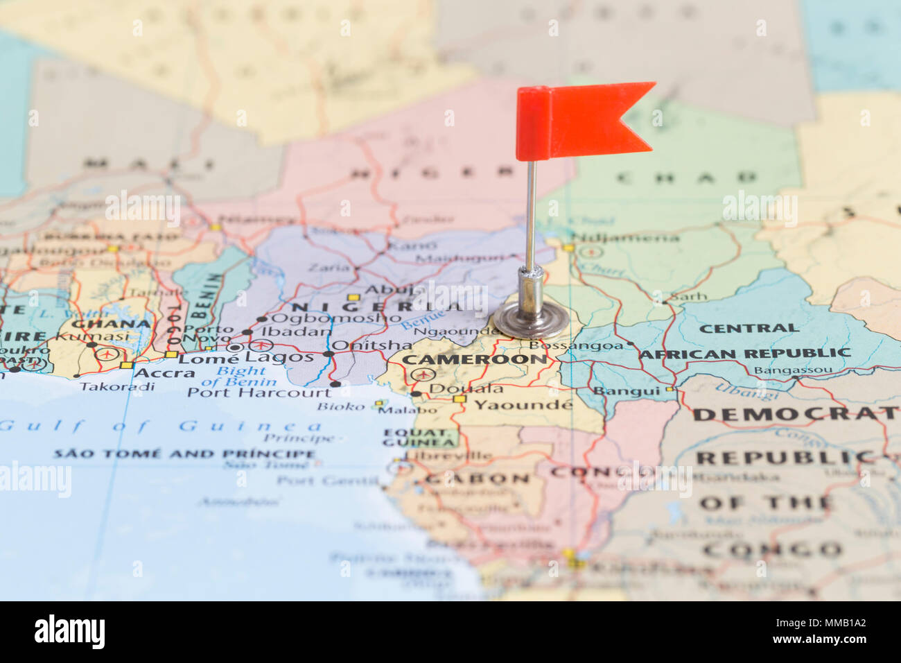 Small red flag marking the African country of Cameroon on a world map ...