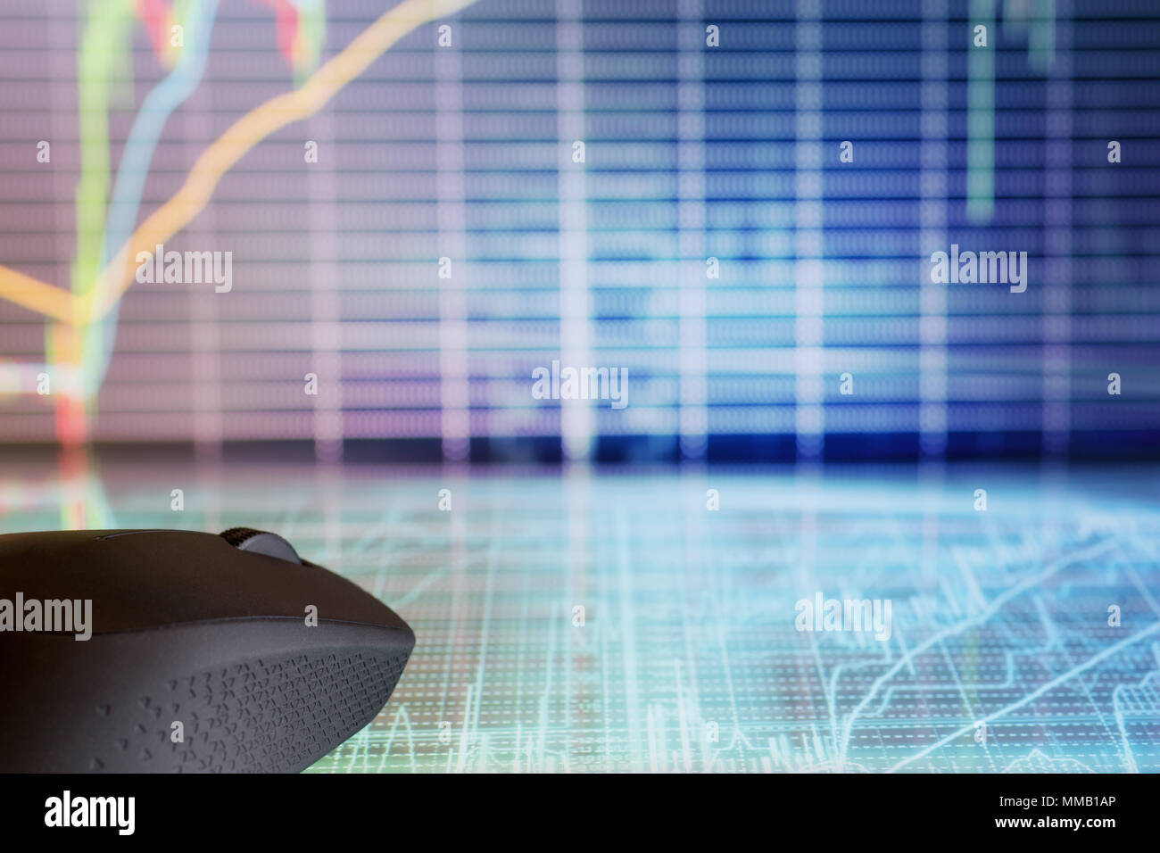 Computer mouse on futuristic display with defocused stock market graphs ...