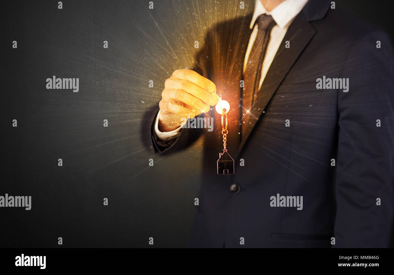 Formal man hand over shiny keys with dark background Stock Photo - Alamy