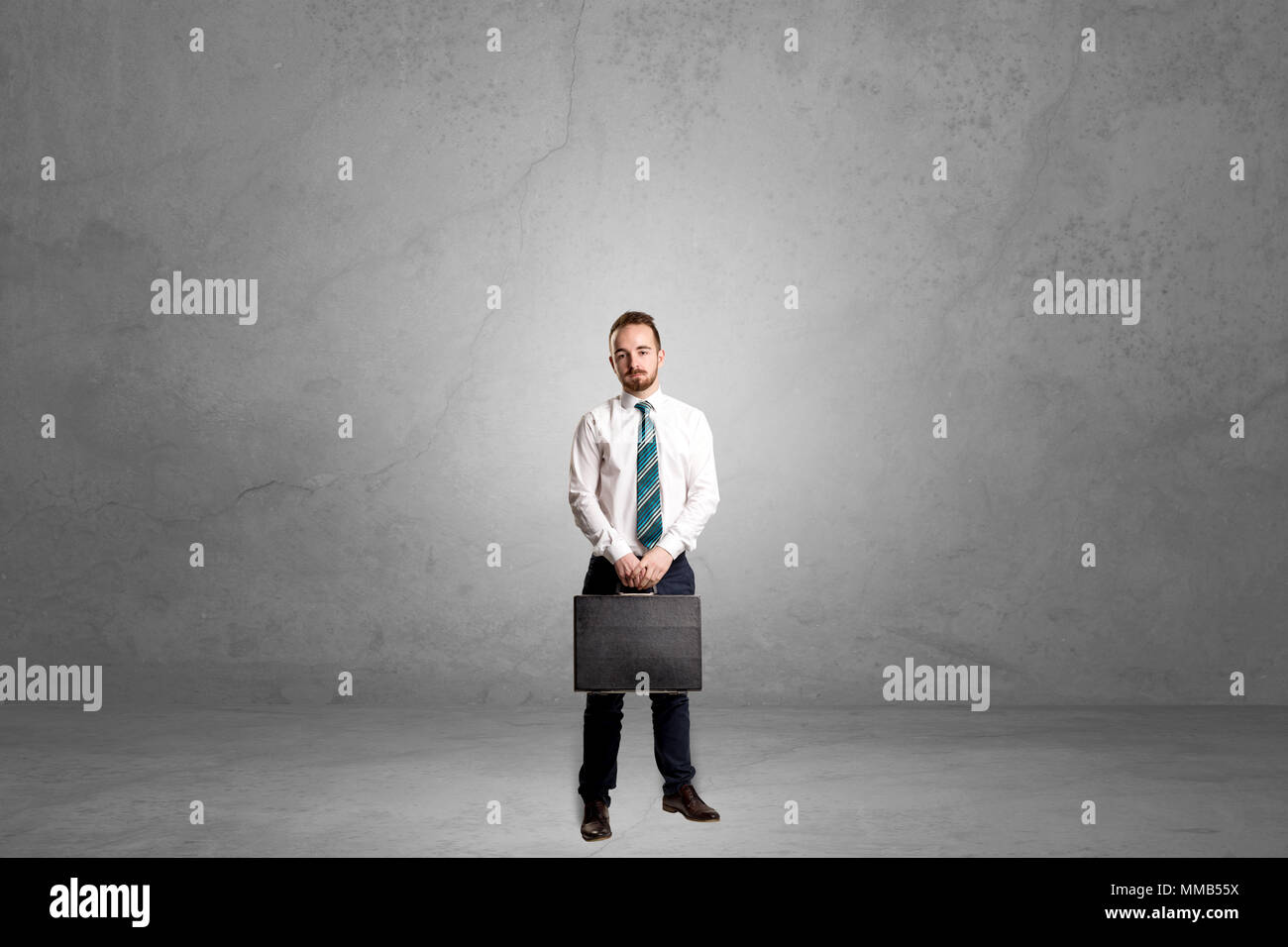 Alone handsome businessman standing in a dark empty room Stock Photo ...