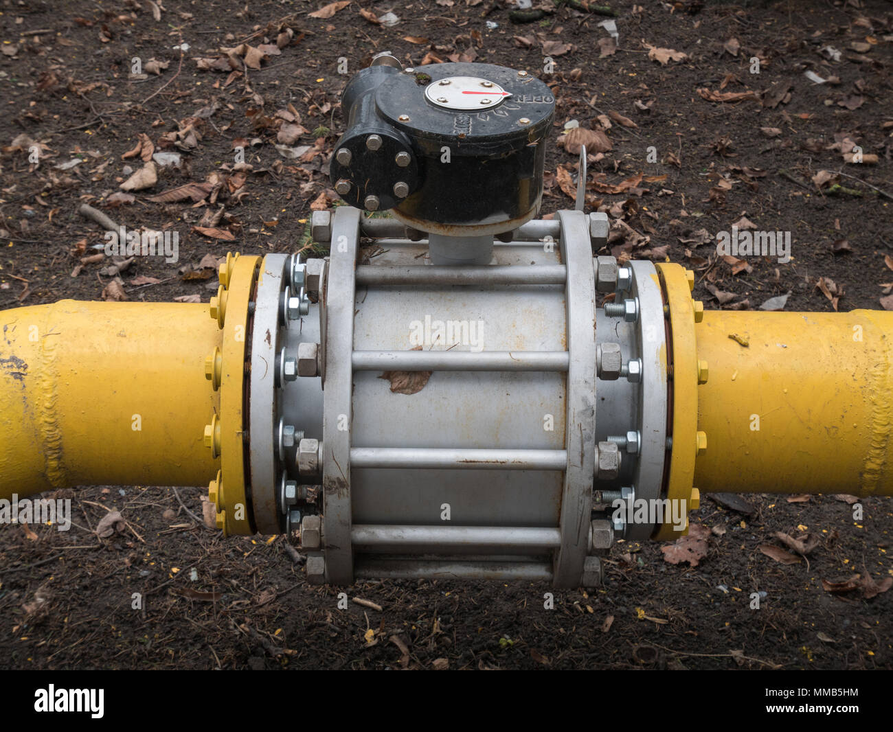 big massive valve on a thick yellow gas water oil steel metal pipelines ...