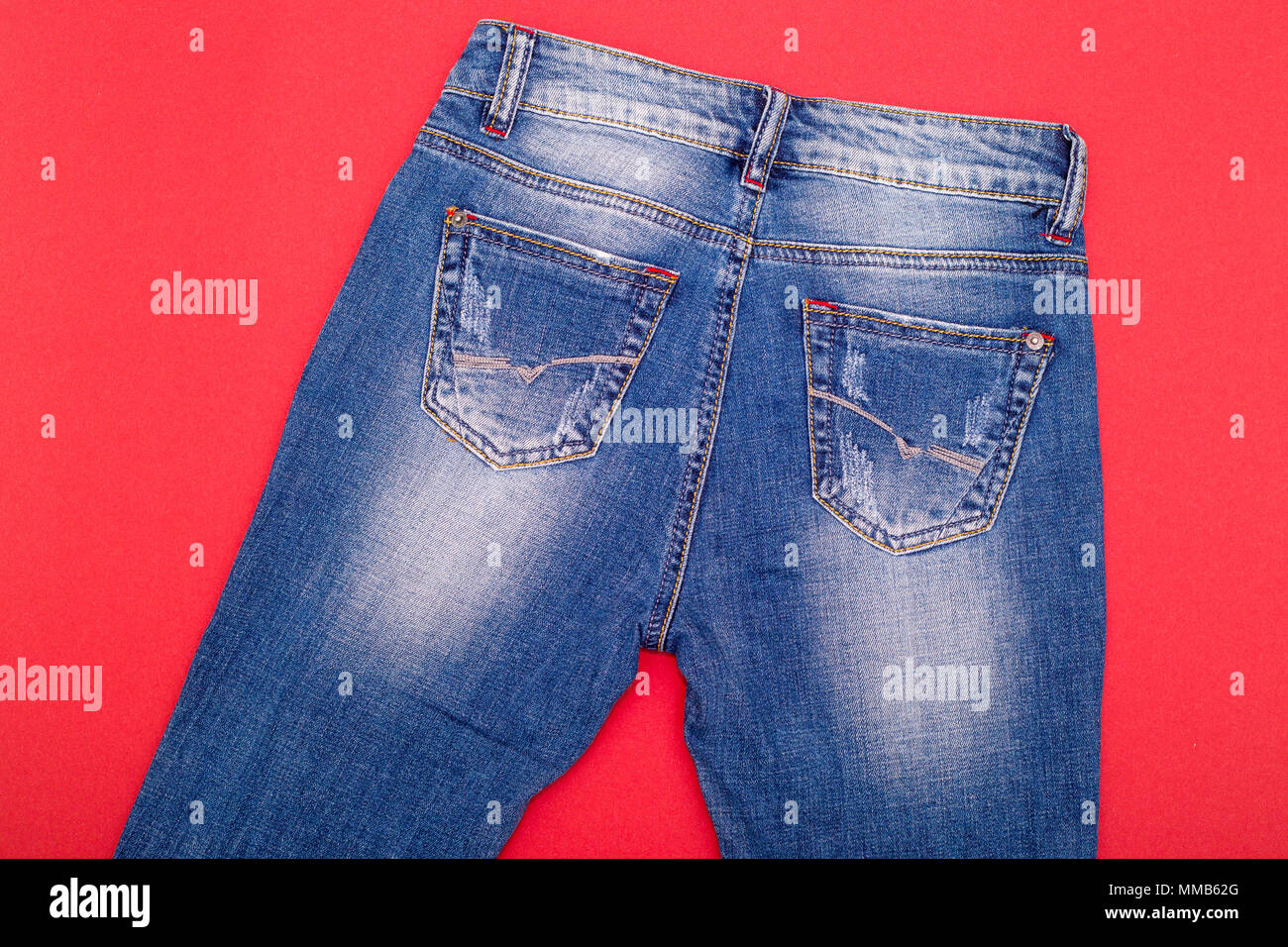 Shabby jeans light blue on a red background Stock Photo - Alamy