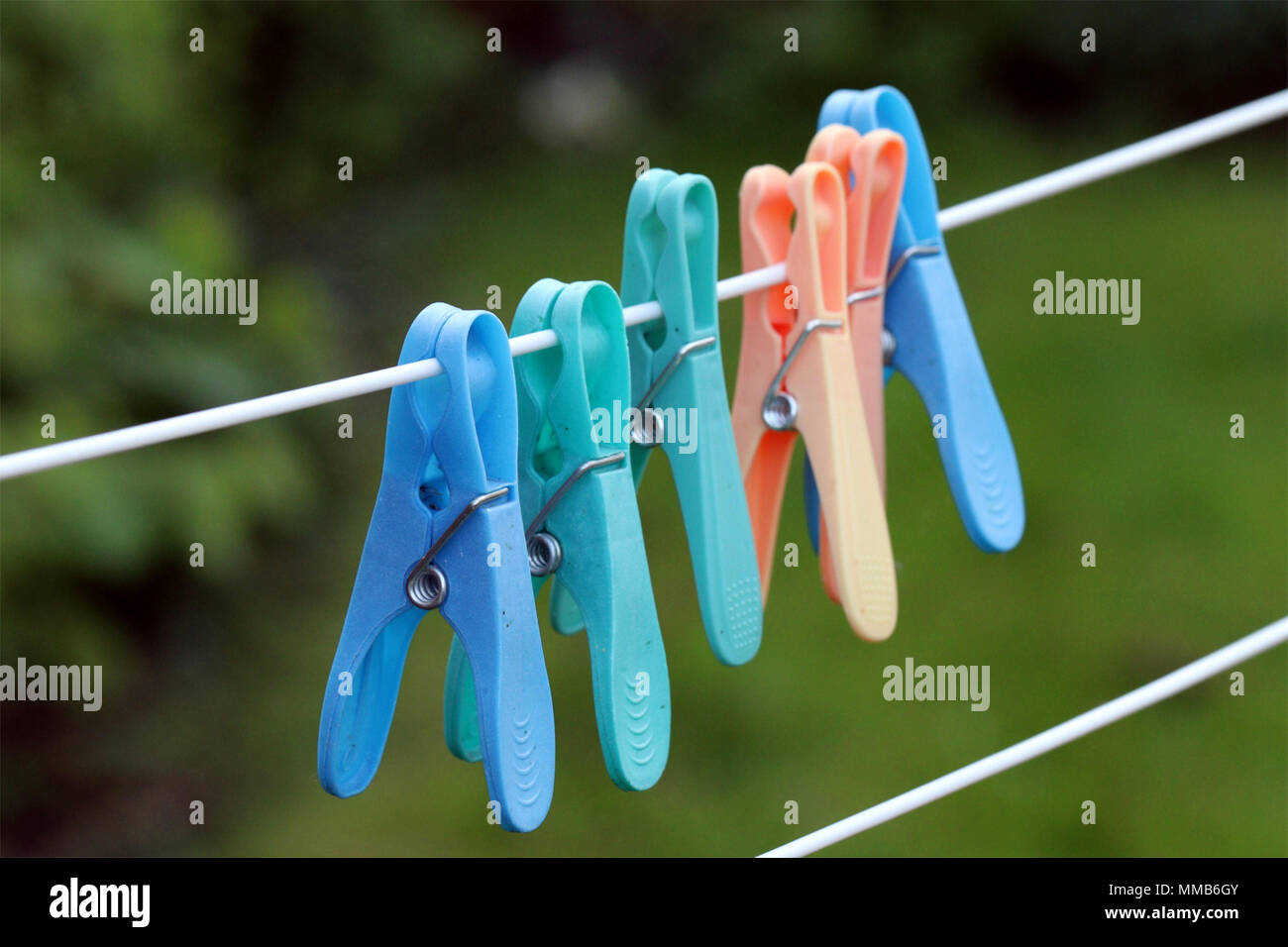 Washing day in the garden, close up of brightly coloured pegs on a ...