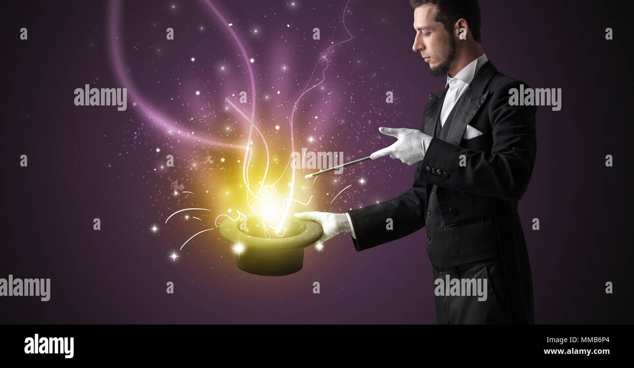 Magician hand conjure with wand light from a black cylinder Stock Photo ...