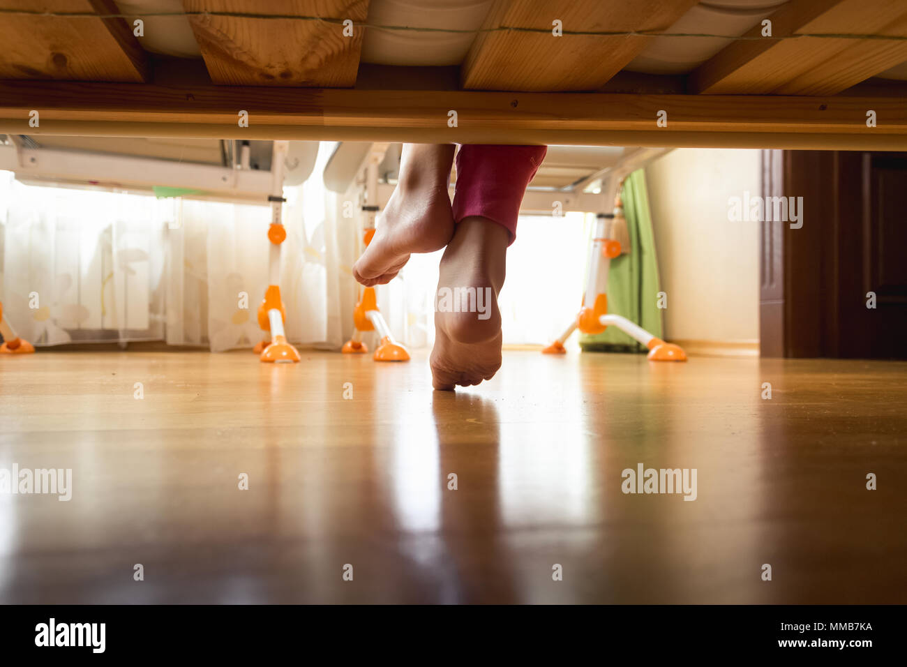 Closeup Photo From Under The Bed Of Barefoot Girls Feet In Bedroom With