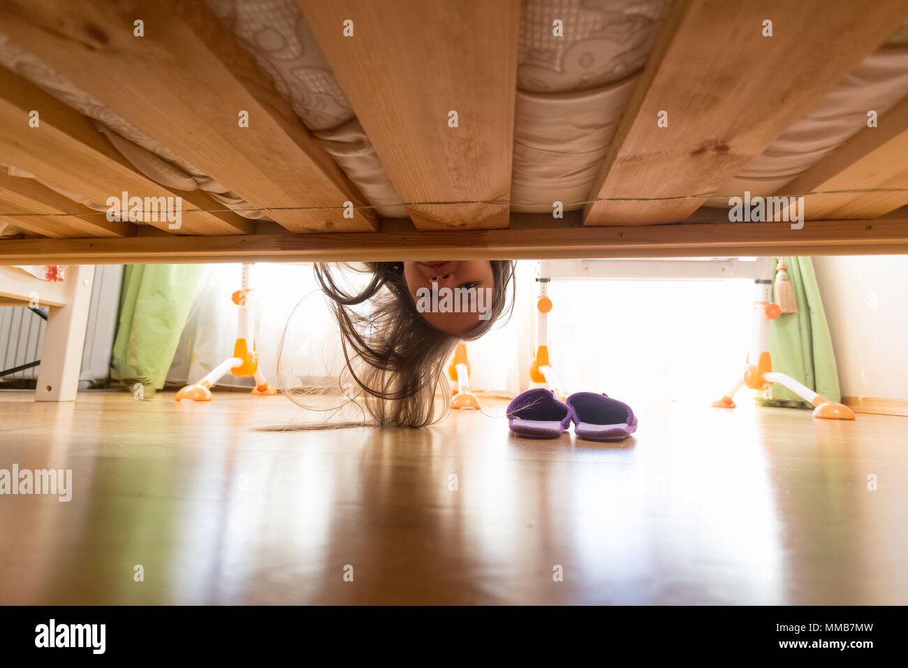Portrait of teenage girl looking under the bed Stock Photo - Alamy