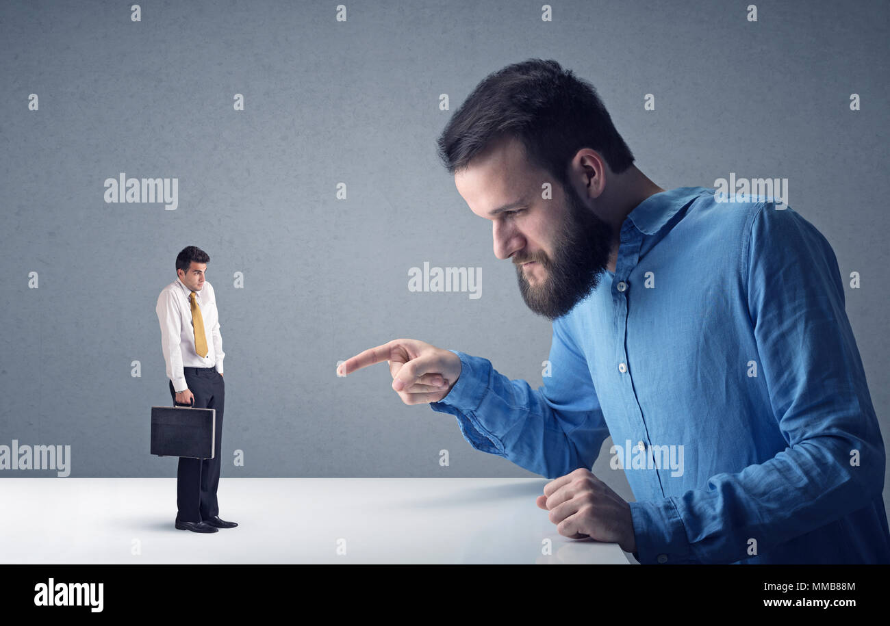 Young professional businessman being angry with an other miniature ...