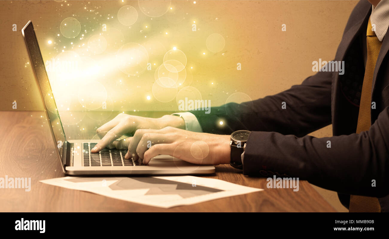An elegant businessman sitting at desk and pushing the buttons of his ...