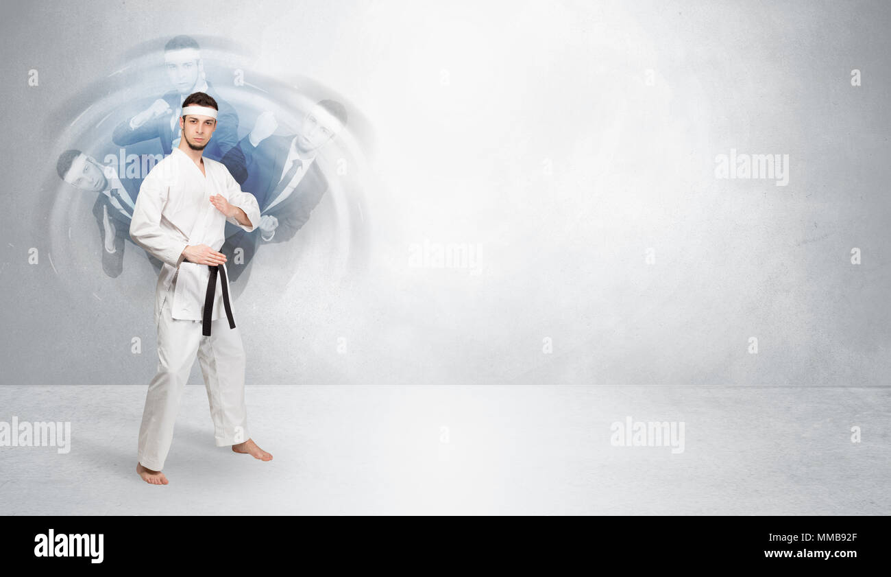 Young businessman in suit fighting with empty wall background Stock ...
