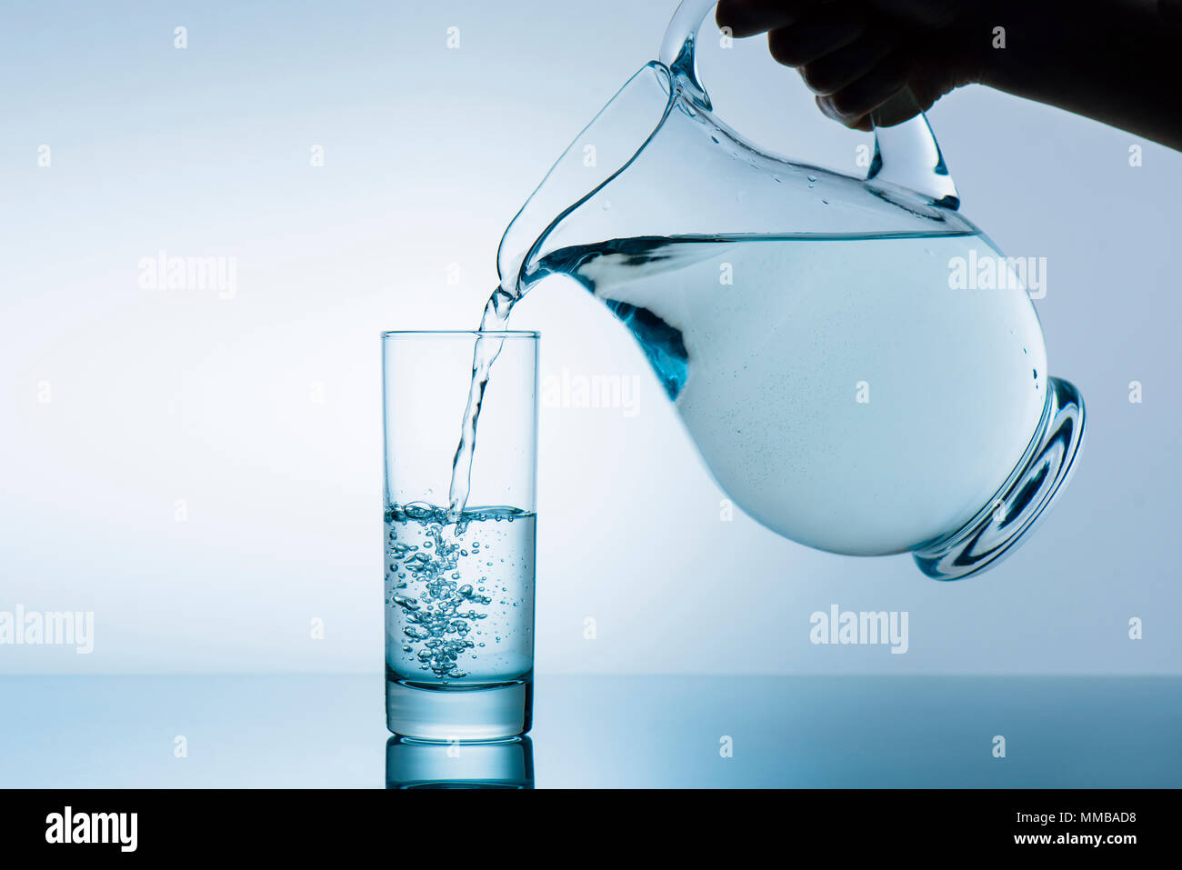 woman pouring water from jug Stock Photo - Alamy