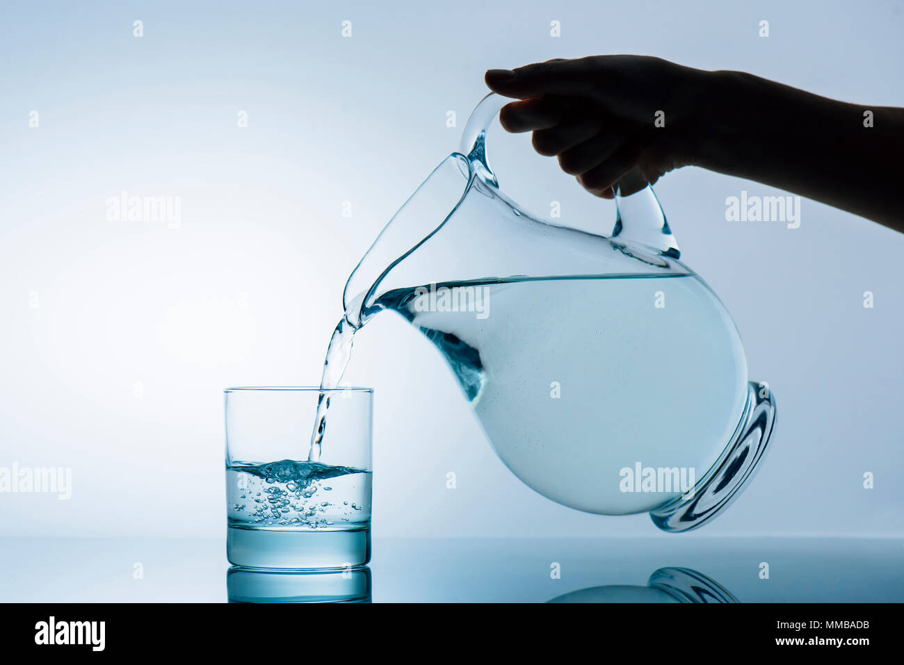woman pouring water from jug Stock Photo - Alamy