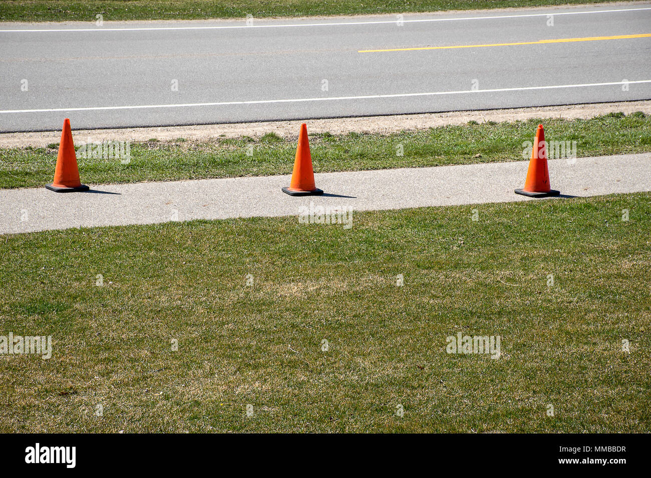 row of orange fluorescent traffic cones on sidewalk Stock Photo - Alamy