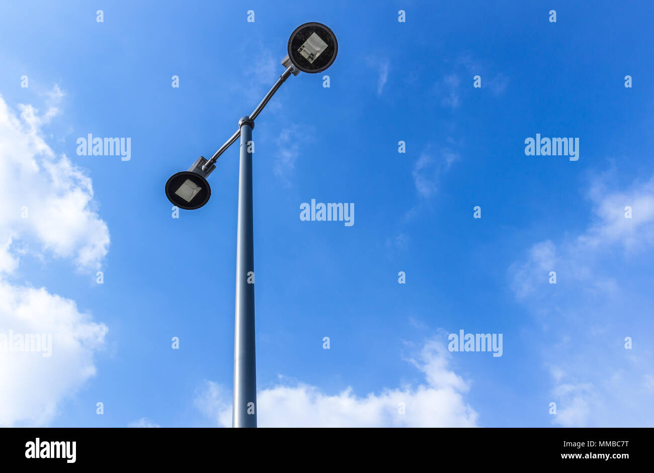 Modern electric street light pole over blue sky with clouds Stock Photo ...