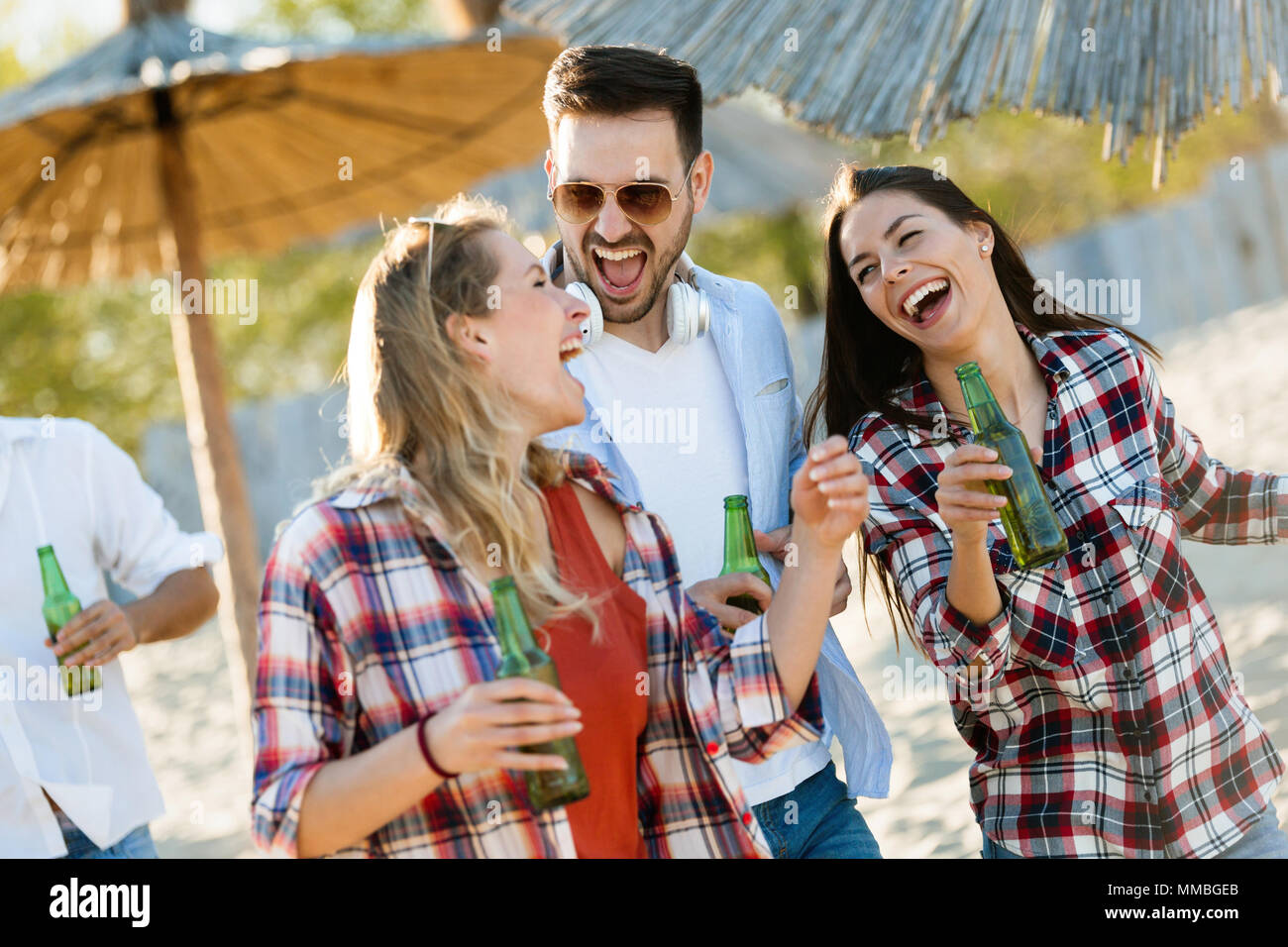 Group of young friends laughing and drinking beer Stock Photo - Alamy