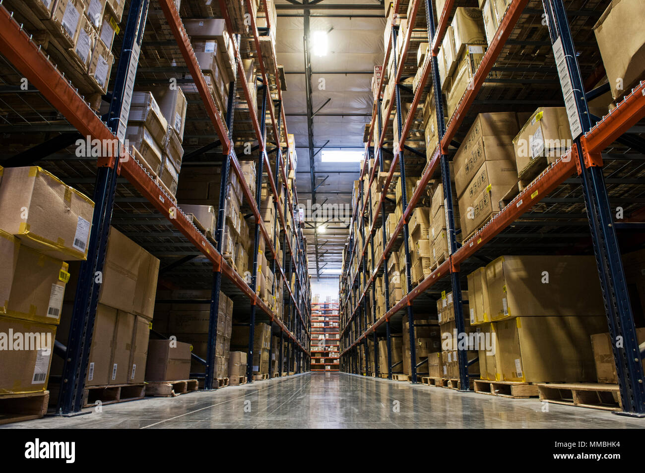 View down an aisle of racks holding cardboard boxes of product on ...