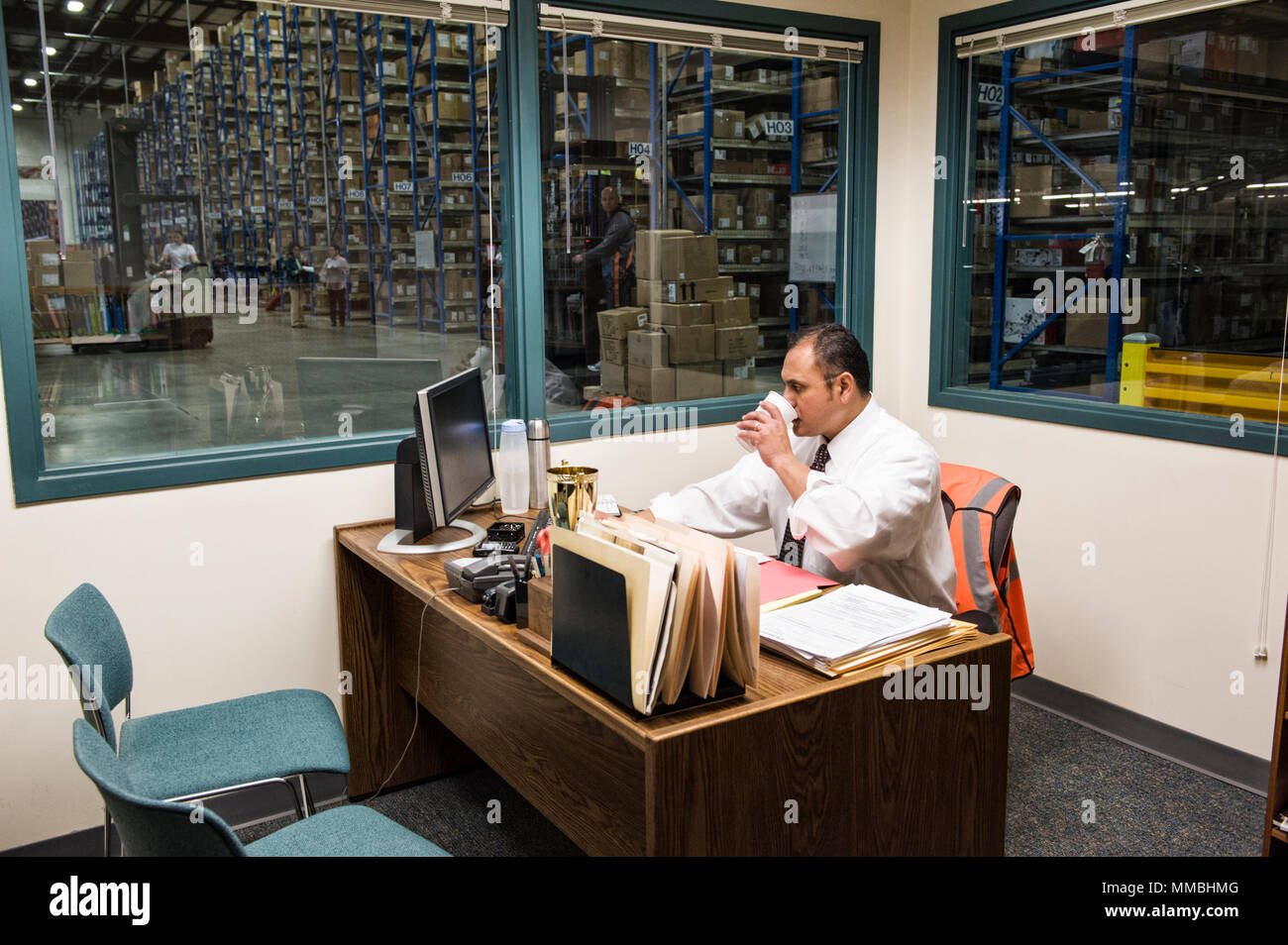 Man sitting on desk in warehouse hi-res stock photography and images ...