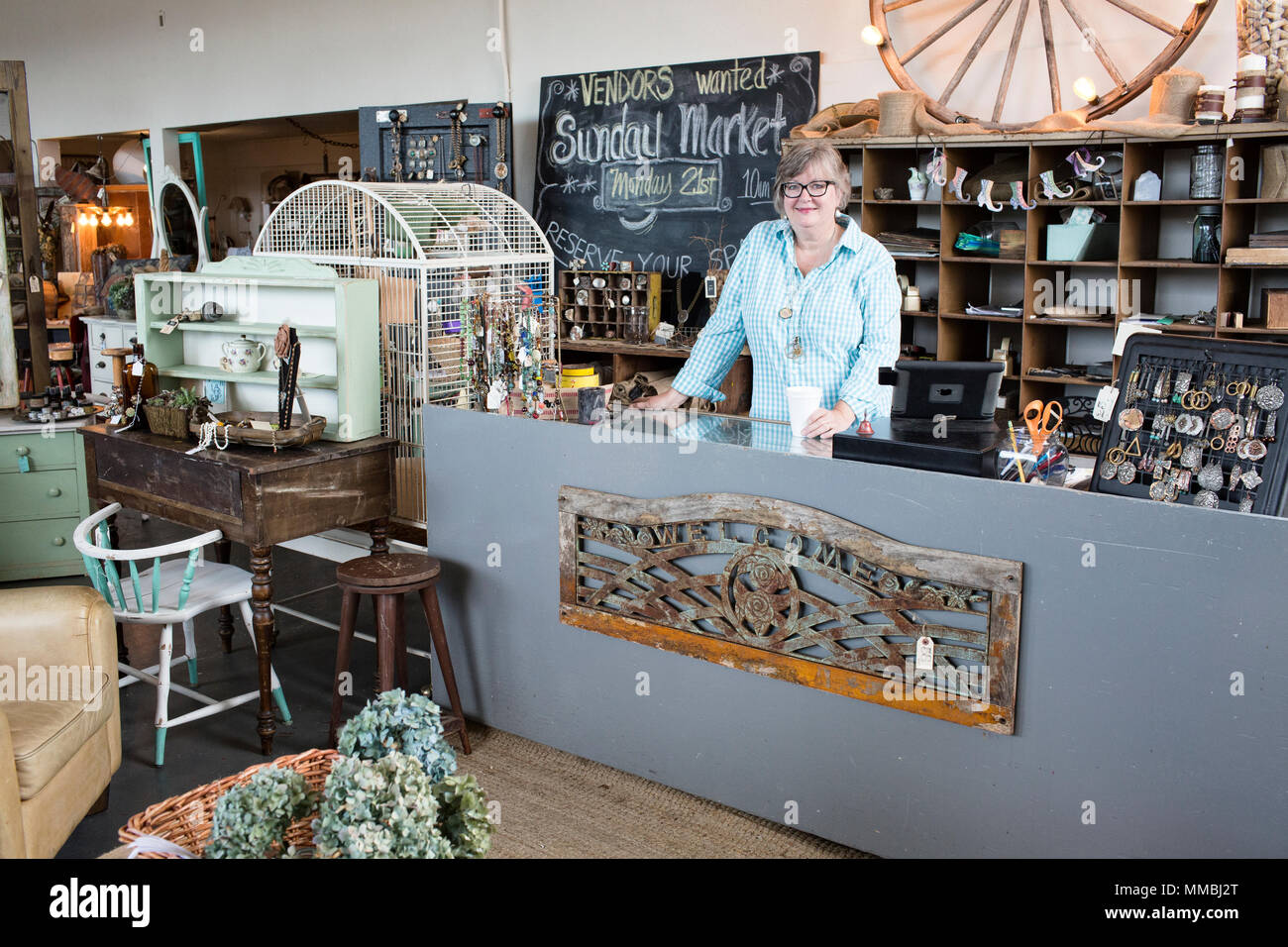 Caucasian woman owner of an antique store standing near the cash ...