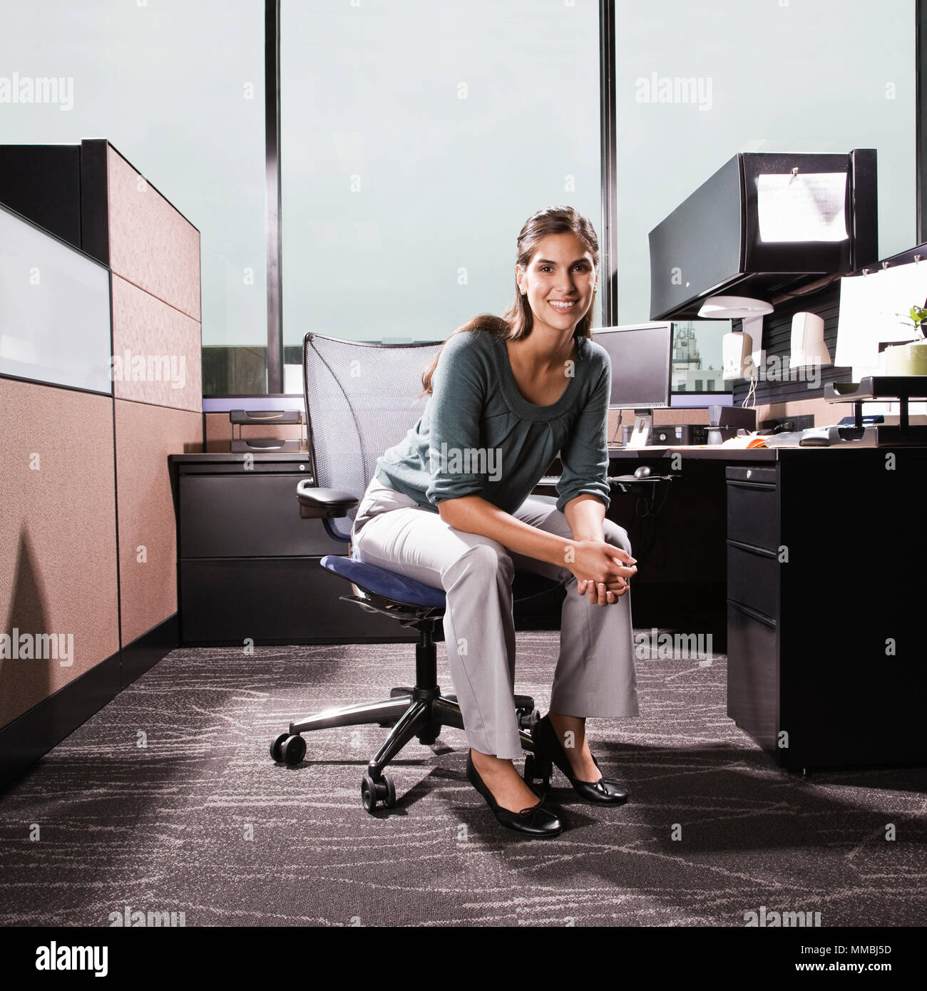 Hispanic woman in an office cubicle Stock Photo - Alamy