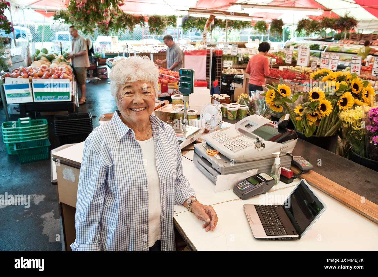 Senior woman standing at the checkout of a food and vegetable market ...