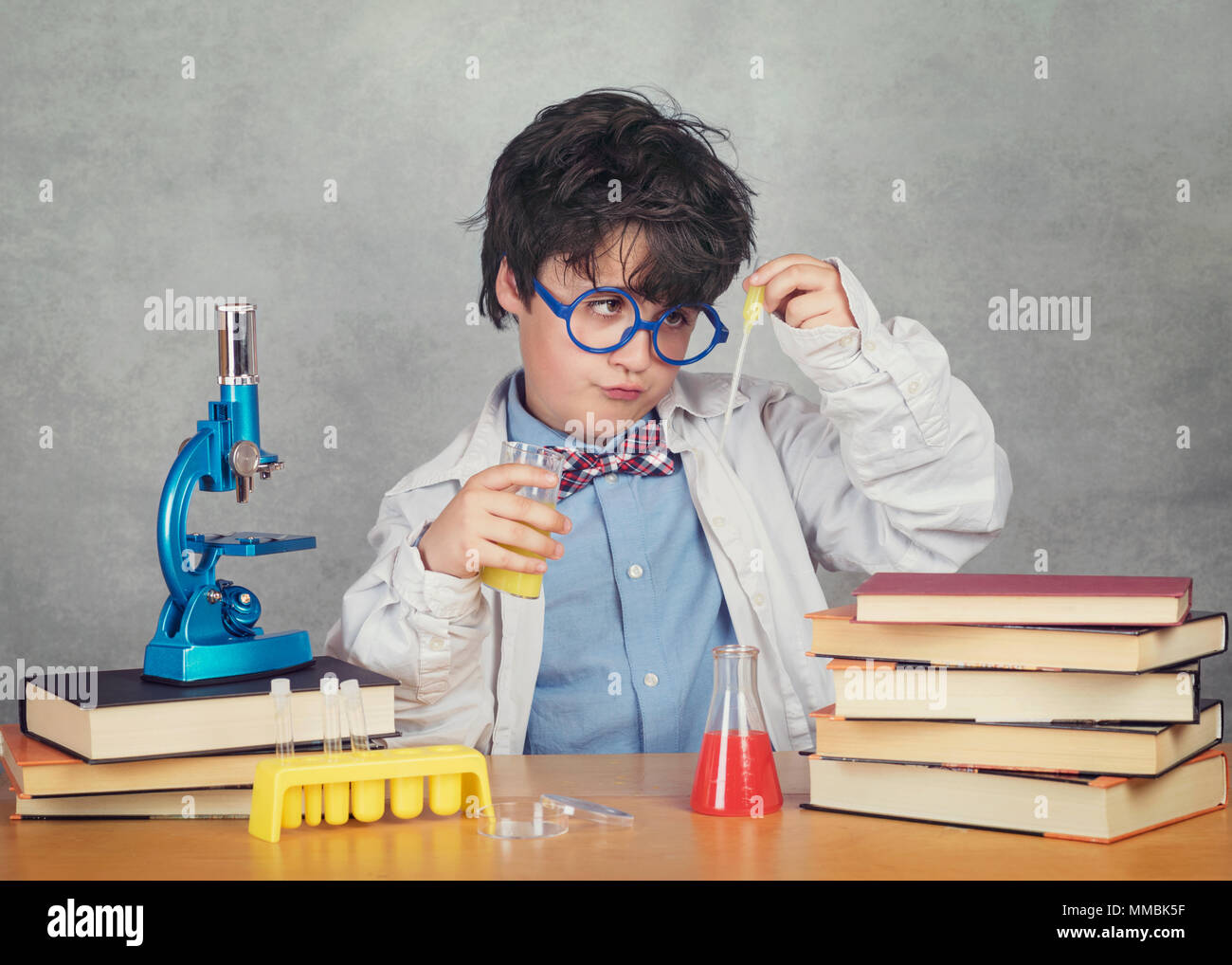 boy is making science experiments in a laboratory on gray background ...