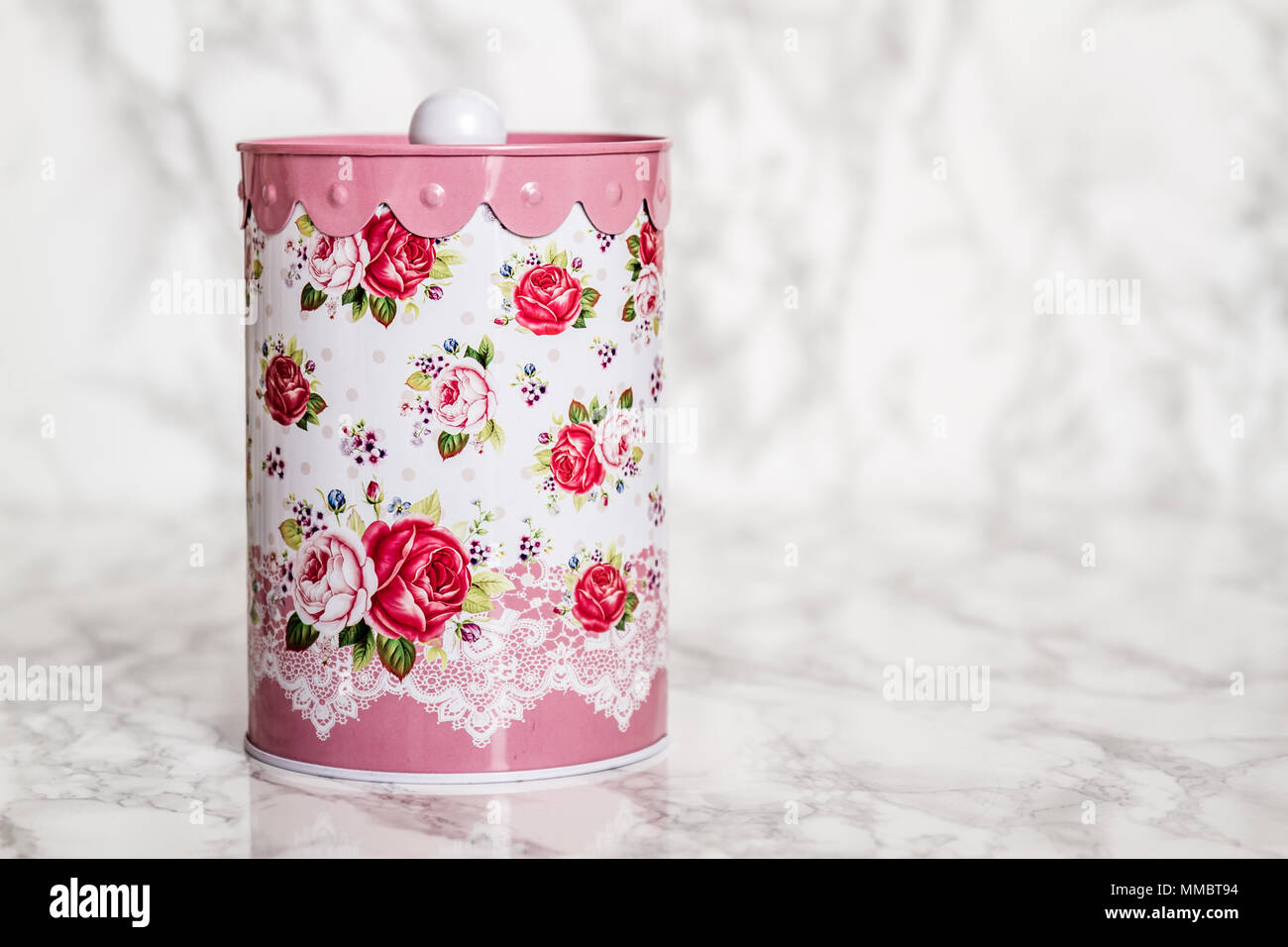 Colorful tin storage container with floral pattern on white background ...