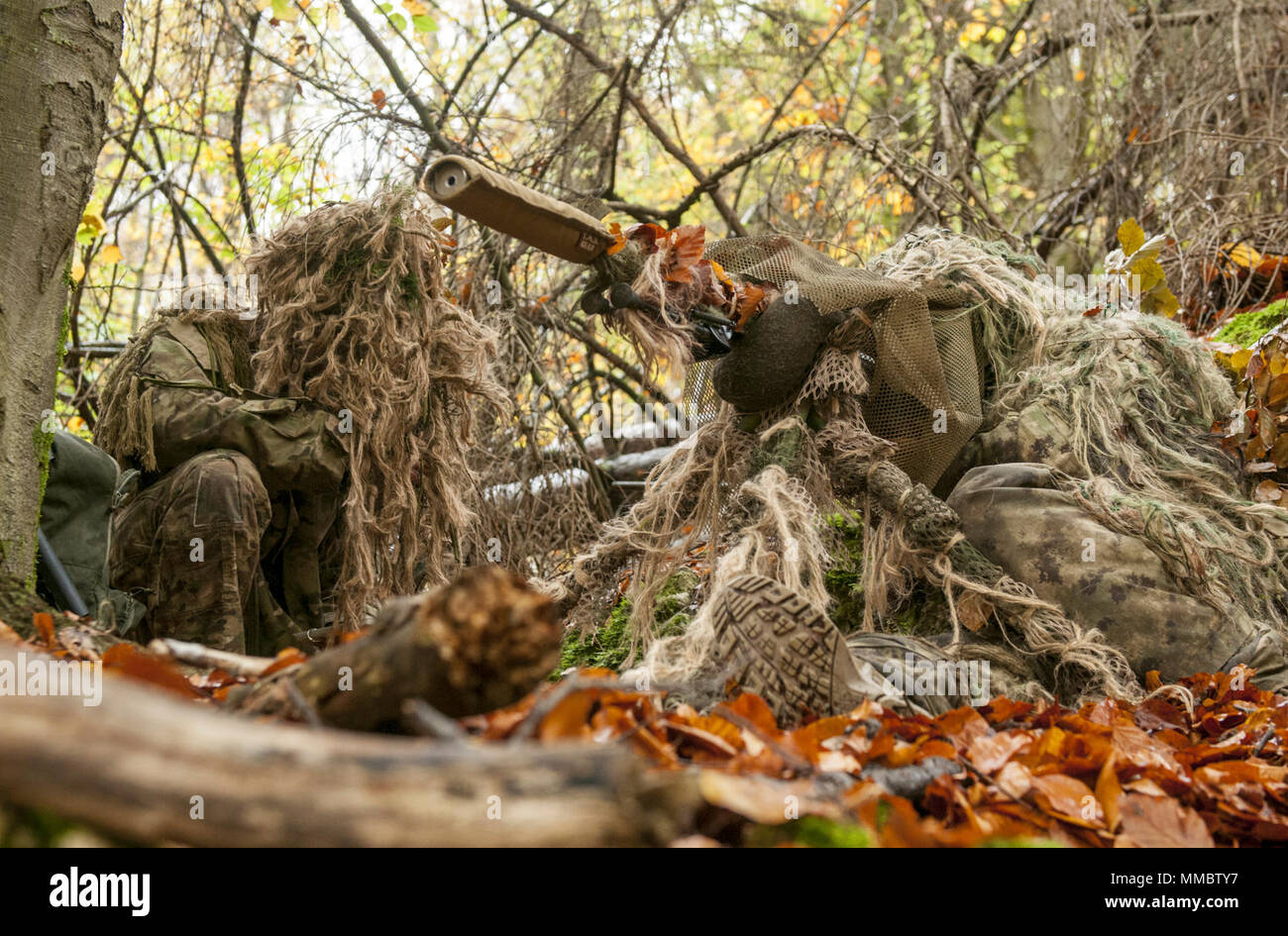 A two-man sniper team prepares to fire while concealed during the Basic ...