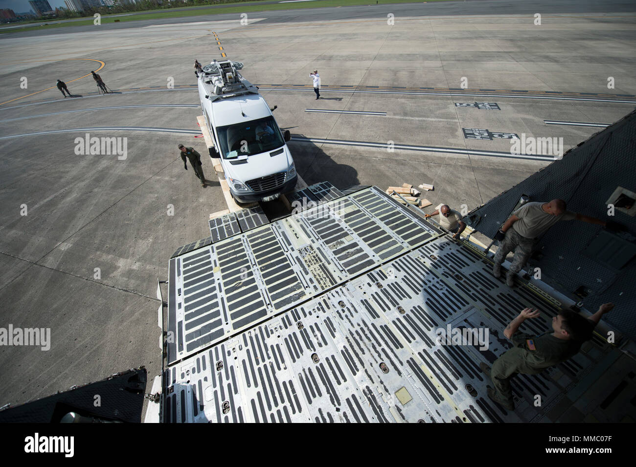 An AT&T mobile telecommunications tower is guided out from a C-5M Super ...