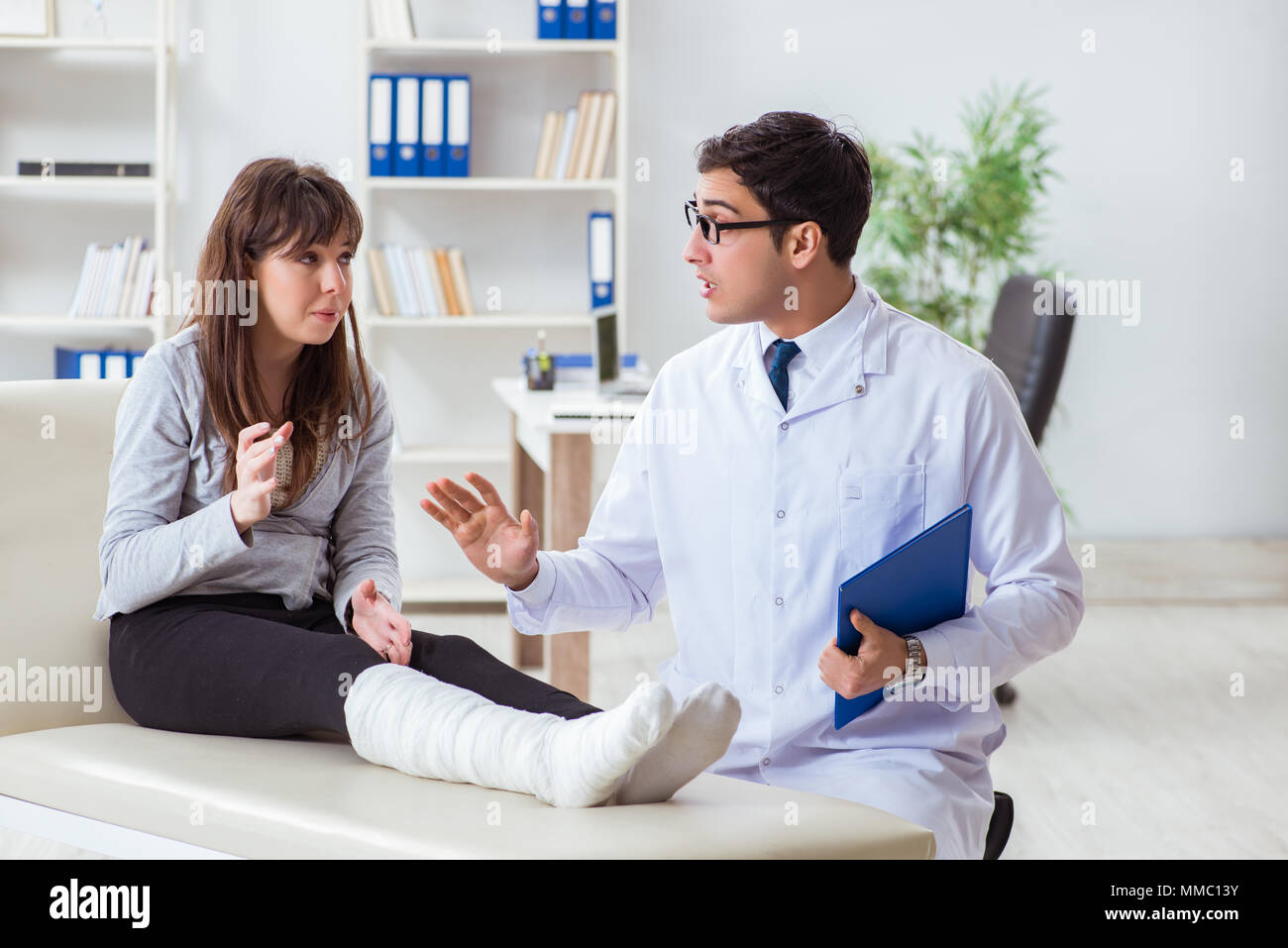 Doctor examining patient with broken leg Stock Photo - Alamy