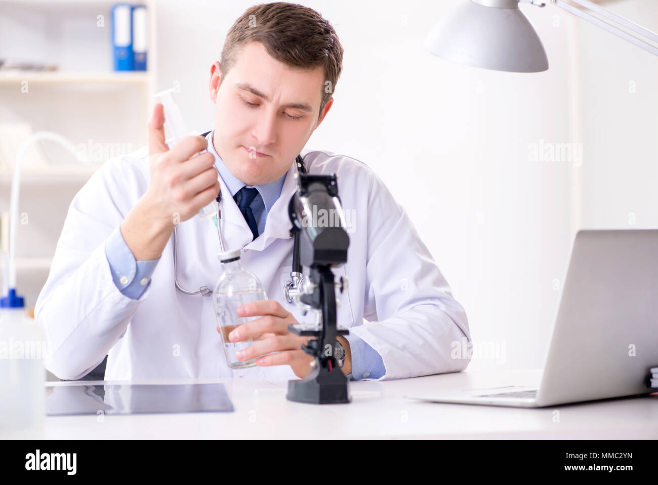 Male doctor looking at lab results in hospital Stock Photo - Alamy