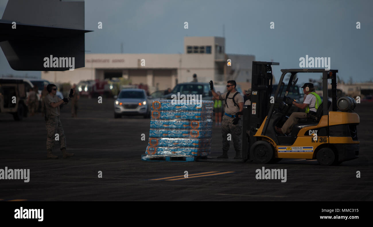 U.S. Airmen load a palet of water onto an MV-22 Osprey, with Marine ...
