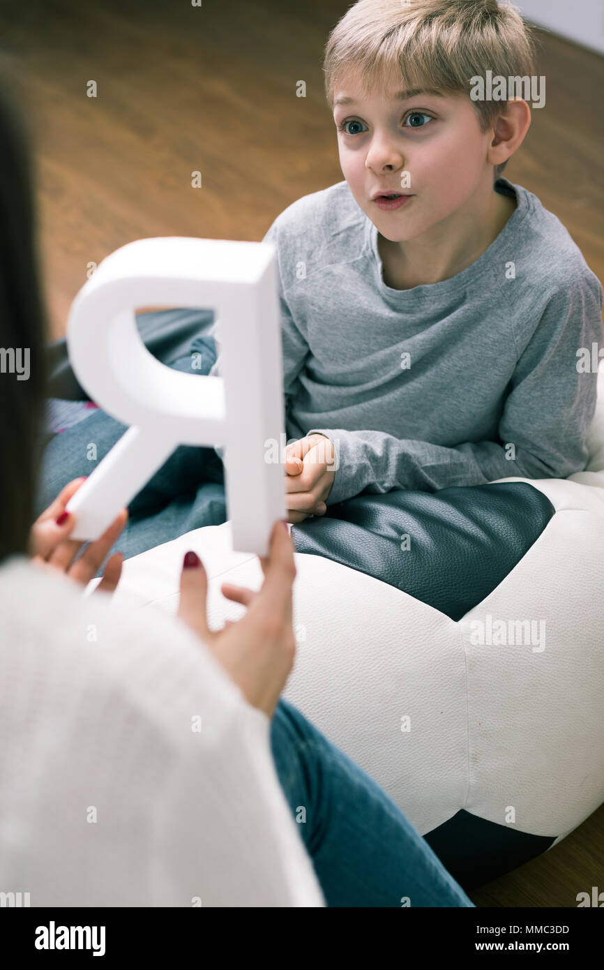 Happy boy and woman holding letter R Stock Photo - Alamy